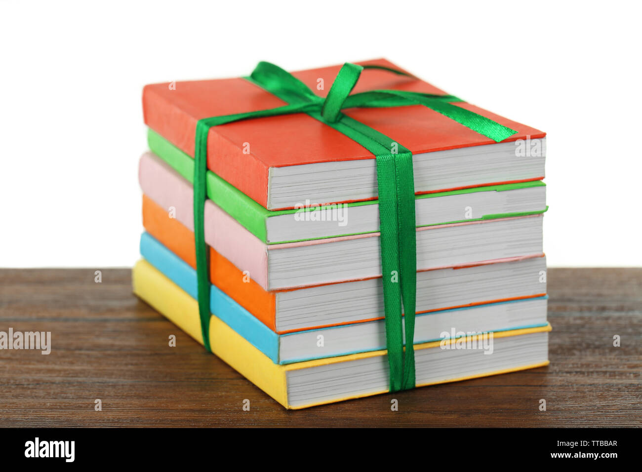 Stack of books with ribbon on light background Stock Photo - Alamy