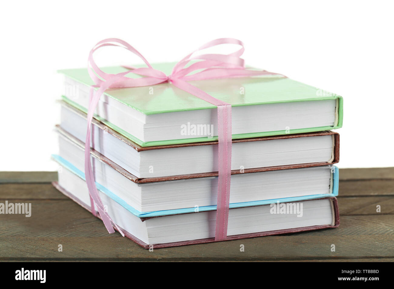 Stack of books with ribbon on light background Stock Photo - Alamy