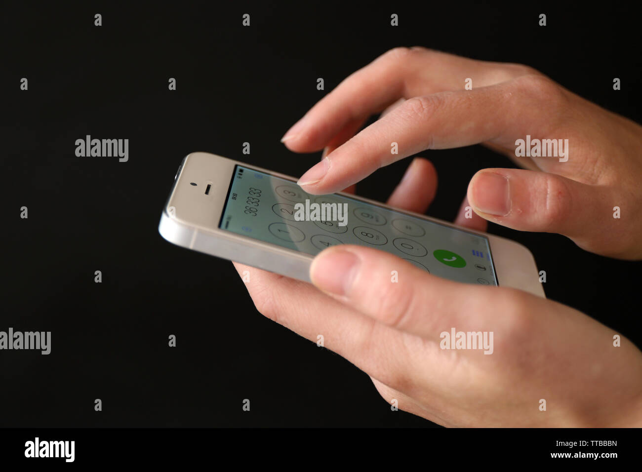 Finger touch number on smartphone to make a call on black background ...