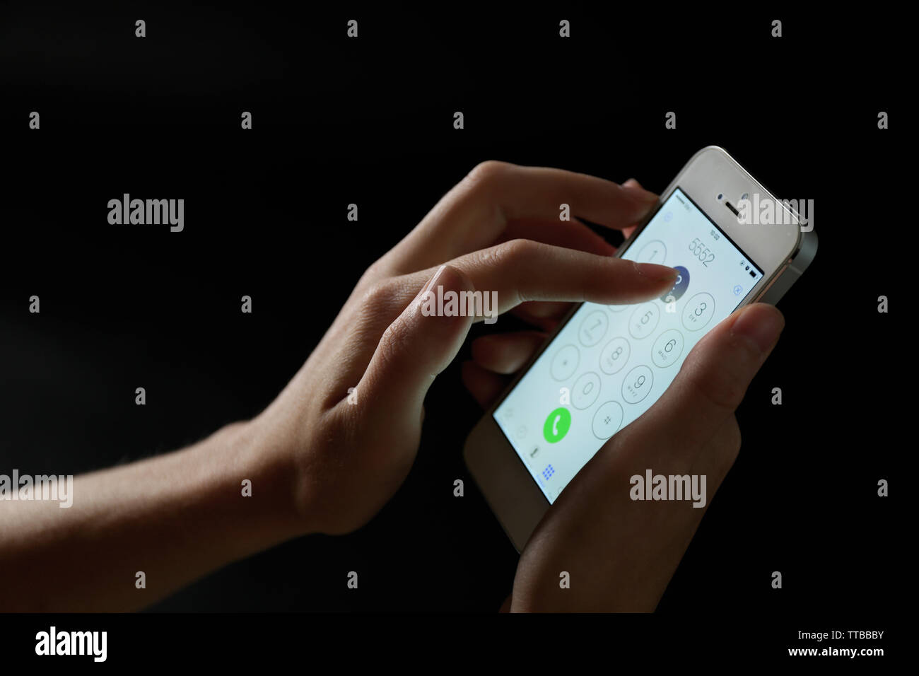 Finger touch number on smartphone to make a call on black background ...