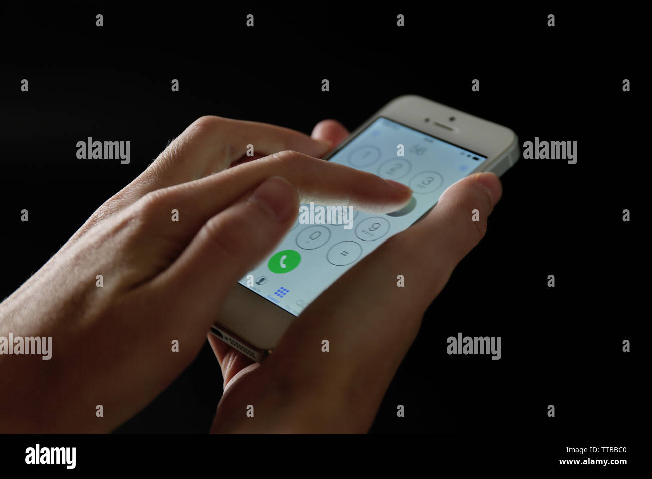 Finger touch number on smartphone to make a call on black background ...