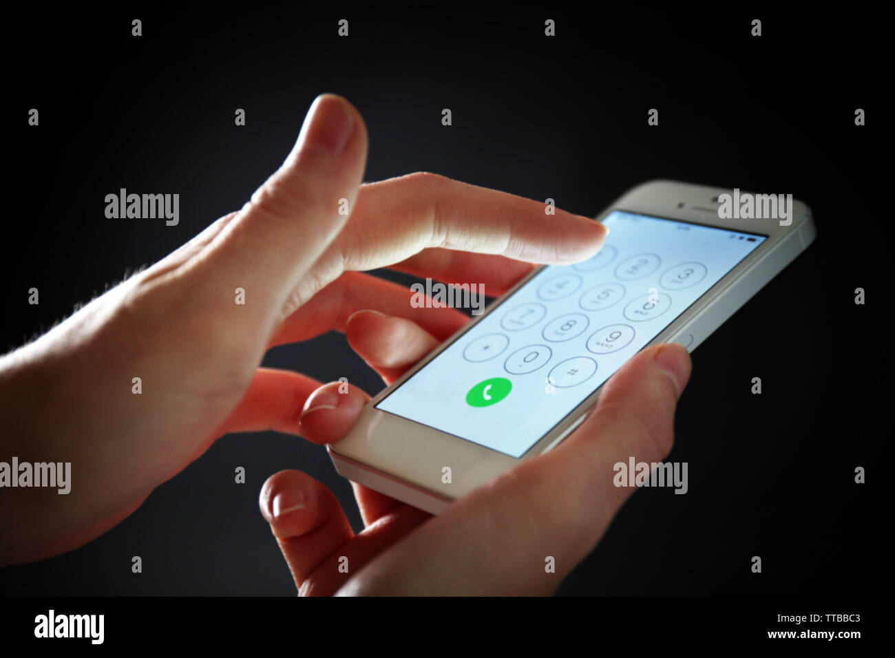 Finger touch number on smartphone to make a call on black background ...