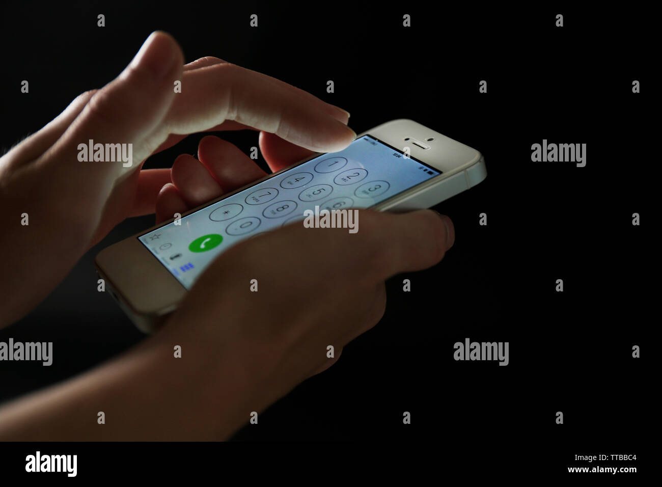 Finger touch number on smartphone to make a call on black background ...