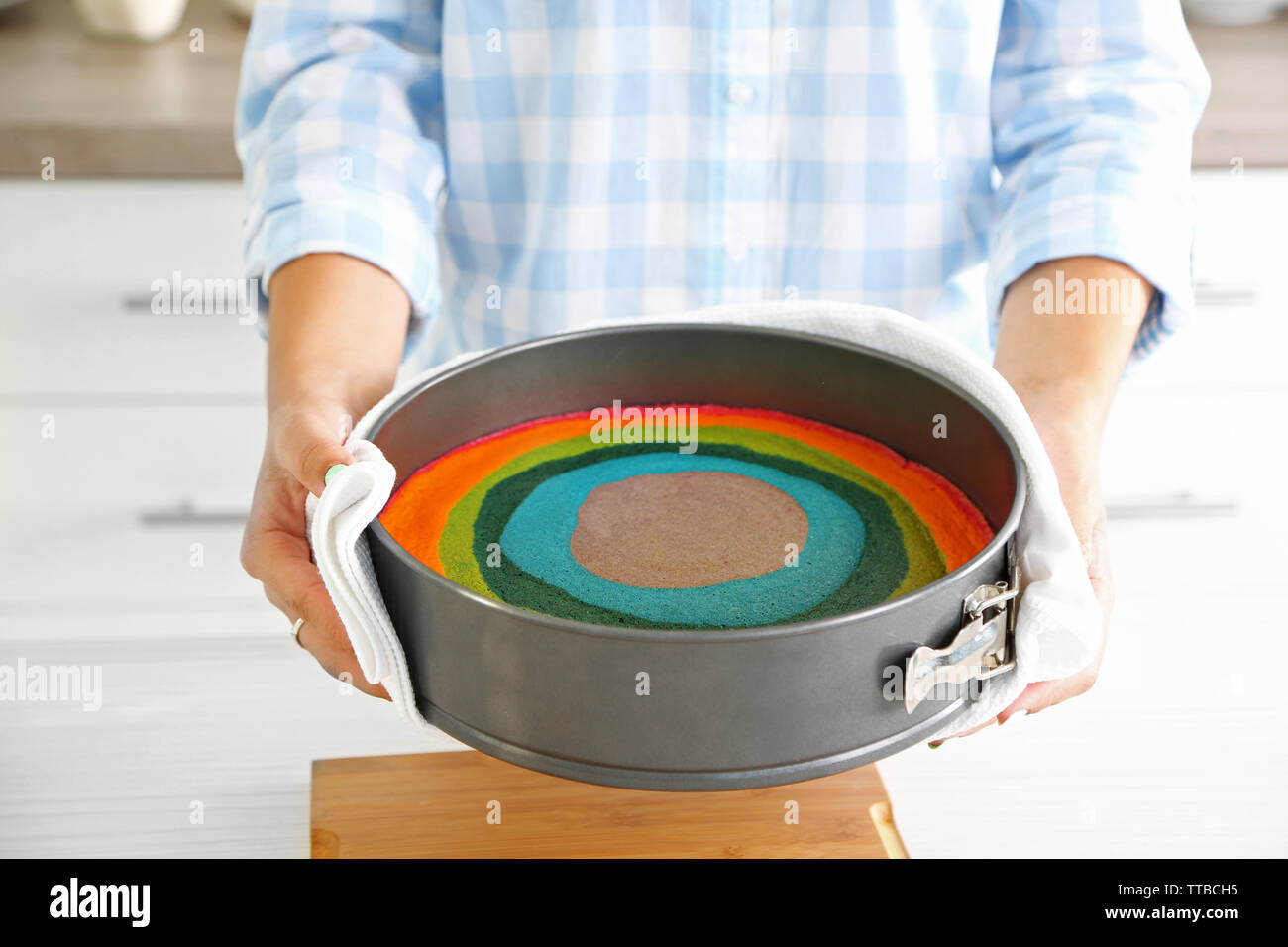 Young woman making rainbow cake in kitchen Stock Photo - Alamy
