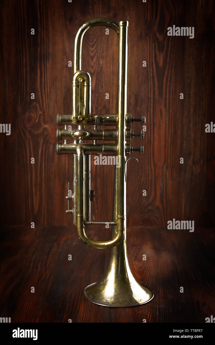 Silver trumpet on wooden background Stock Photo - Alamy