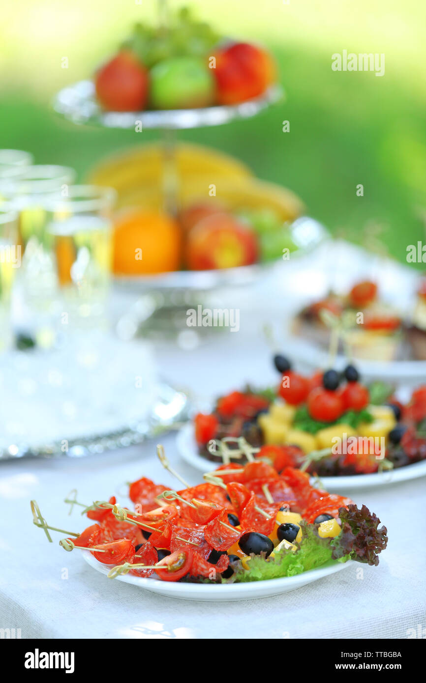 Snacks, fruits and drinks on table, outdoors. Garden party concept ...