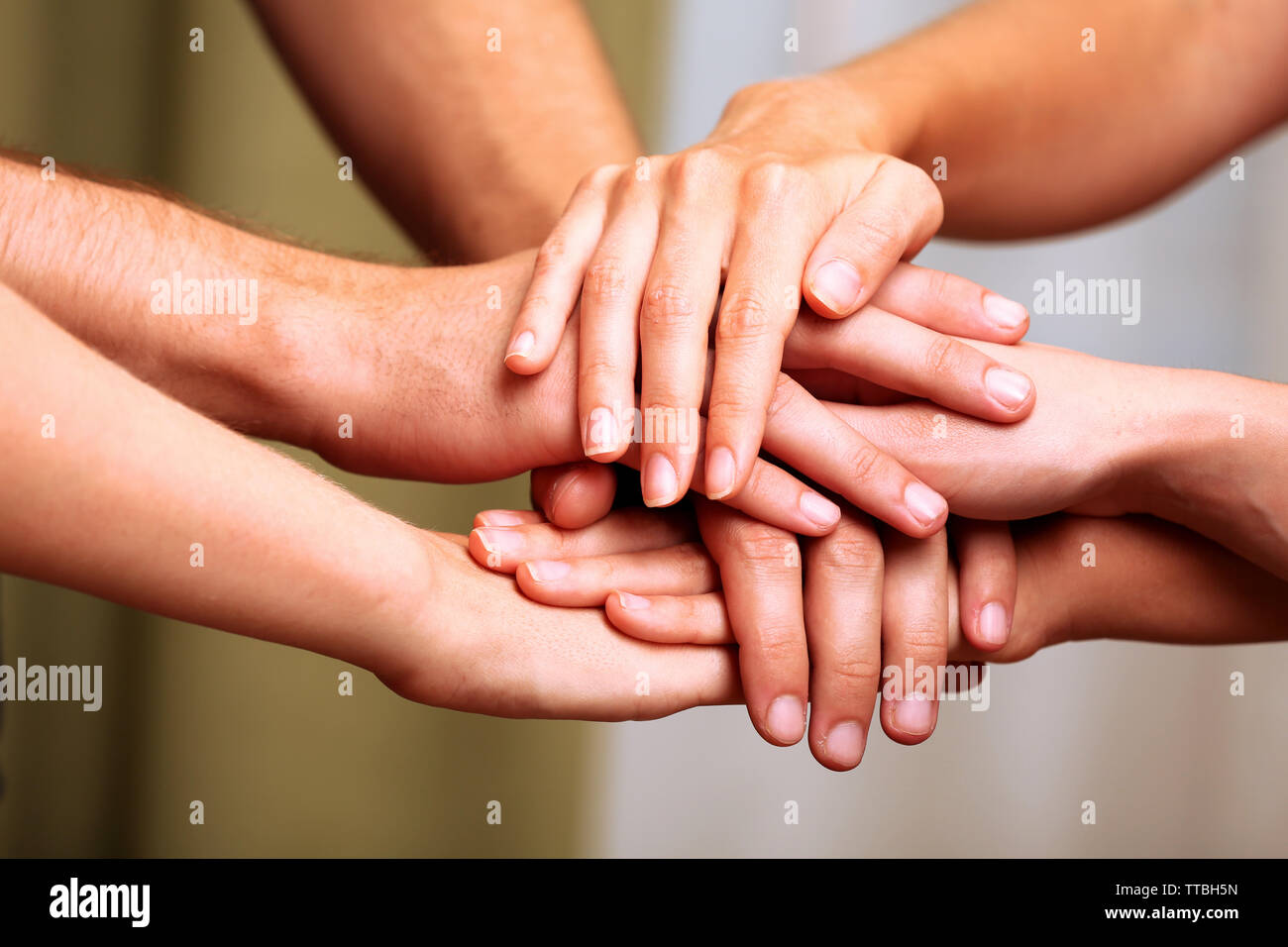 United hands on light background Stock Photo - Alamy