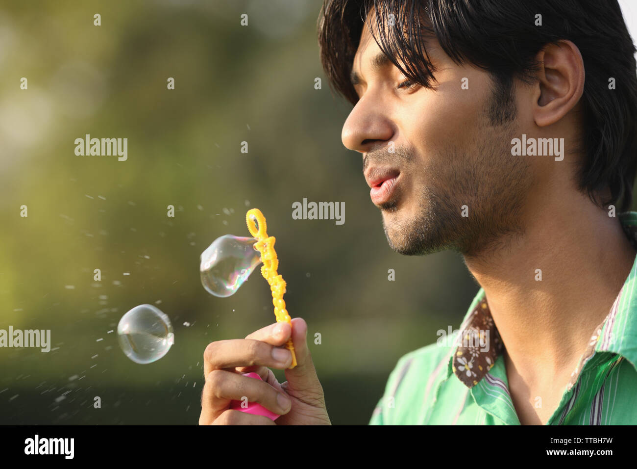 Man blowing bubbles with a bubble wand Stock Photo - Alamy