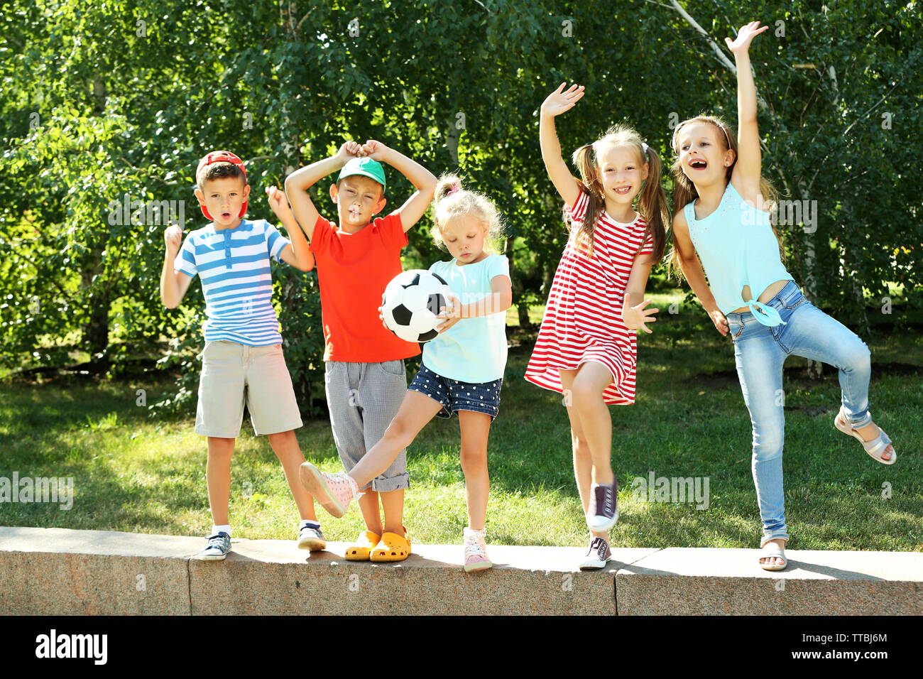 Happy active children playing with football in park Stock Photo - Alamy