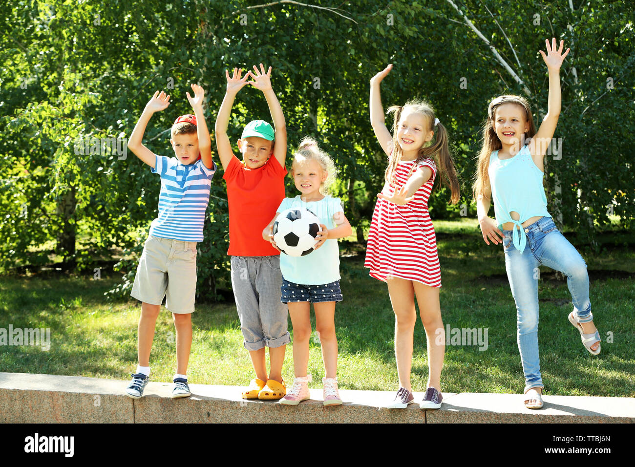 Happy active children playing with football in park Stock Photo - Alamy