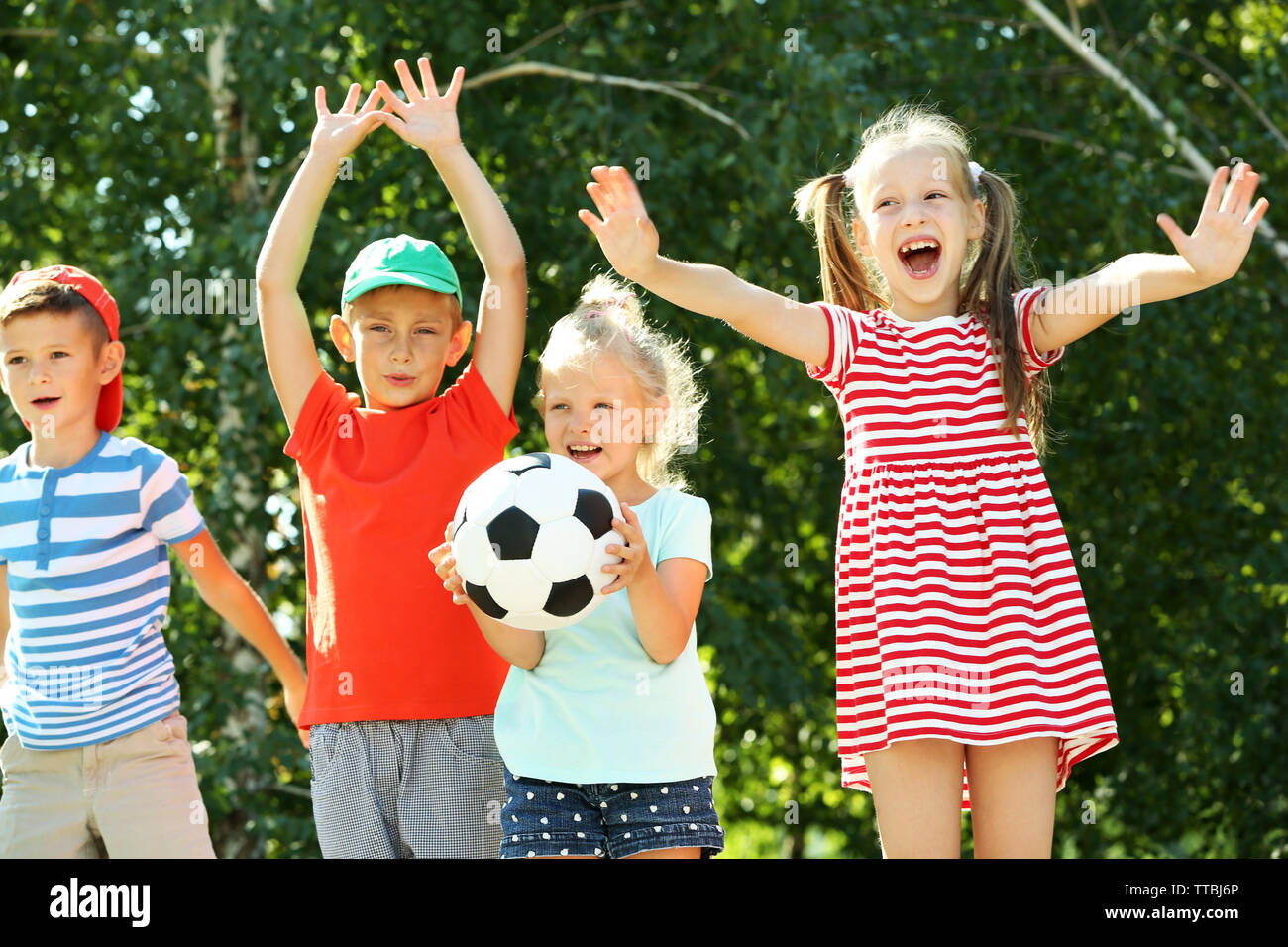 Happy active children playing with football in park Stock Photo - Alamy