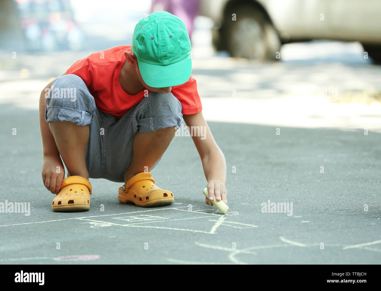 Small boy drawing with chalk on asphalt Stock Photo - Alamy
