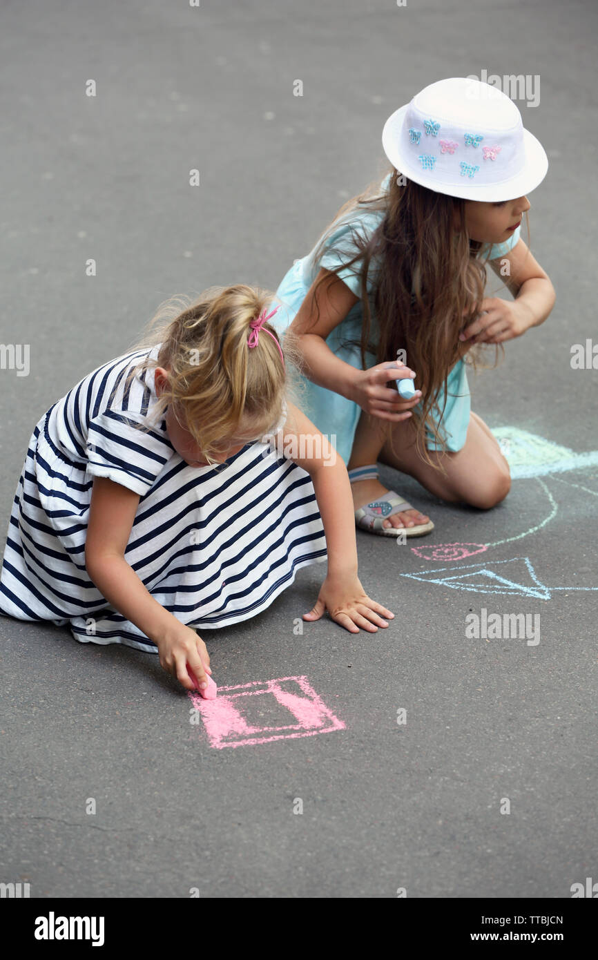 Happy active children drawing with chalk on asphalt Stock Photo - Alamy