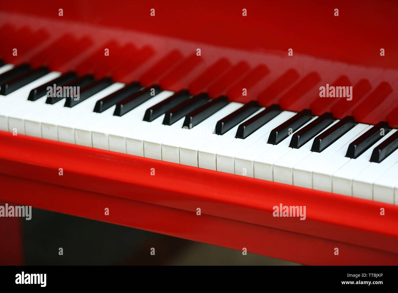 Piano keys of red piano close up Stock Photo - Alamy