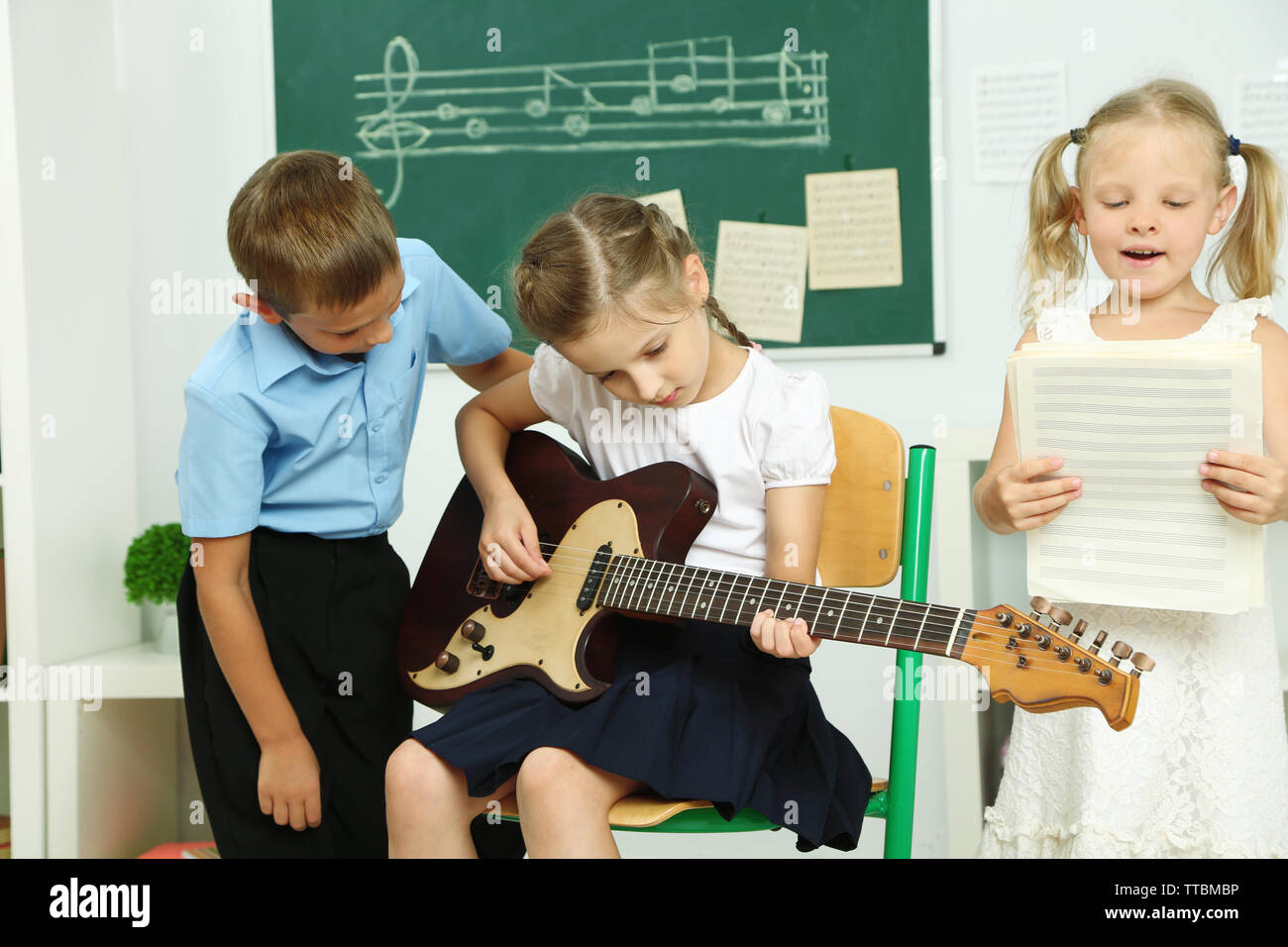 Cute pupils having music lesson in classroom at elementary school Stock ...