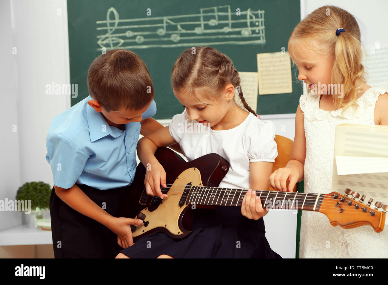 Cute pupils having music lesson in classroom at elementary school Stock ...