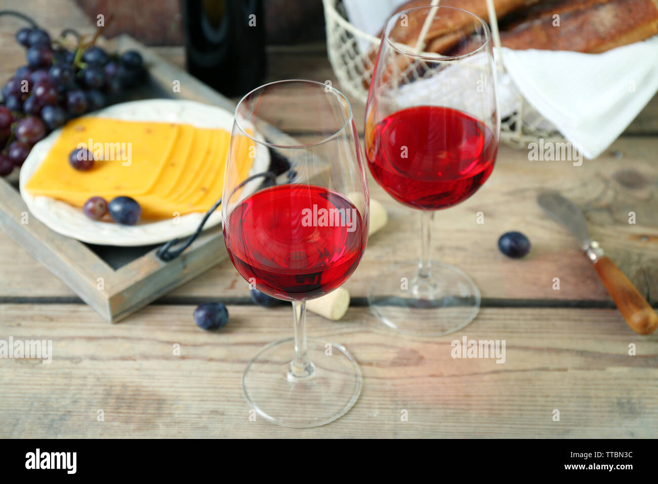 Still life of wine, grape, cheese and bread on rustic wooden background ...