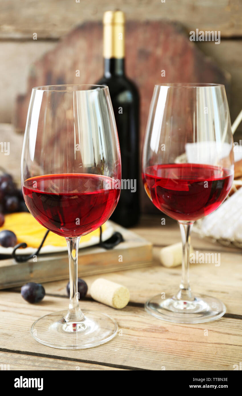 Still life of wine, grape, cheese and bread on rustic wooden background ...