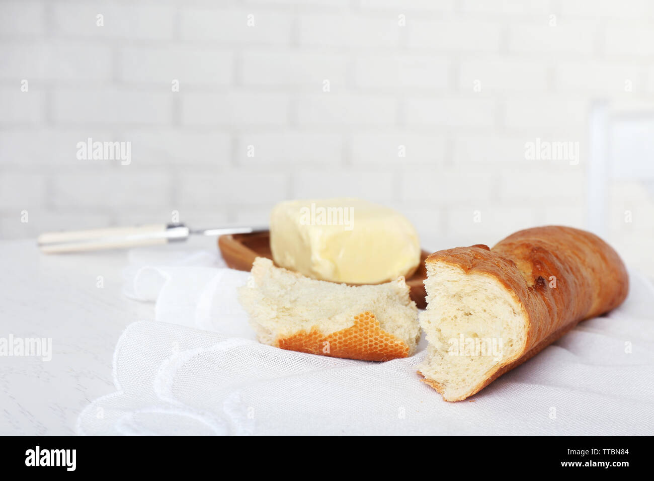 Broken baguette and butter on light background Stock Photo - Alamy