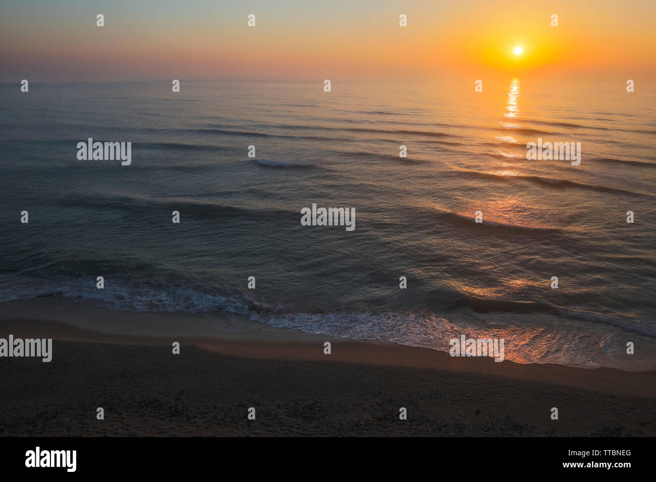 Color image of the sun rising over the horizon by the sea Stock Photo ...