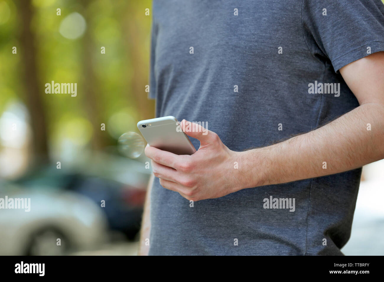 Man holding smart mobile phone outdoors Stock Photo - Alamy