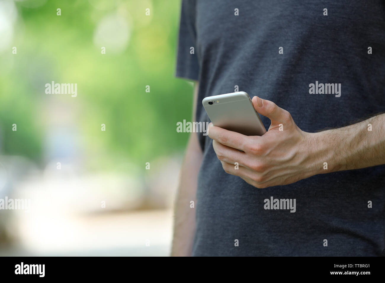 Man holding smart mobile phone outdoors Stock Photo - Alamy