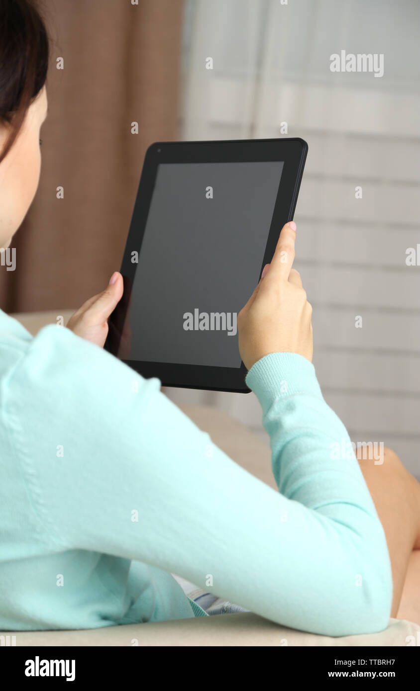 Female hand holding PC tablet on home interior background Stock Photo ...
