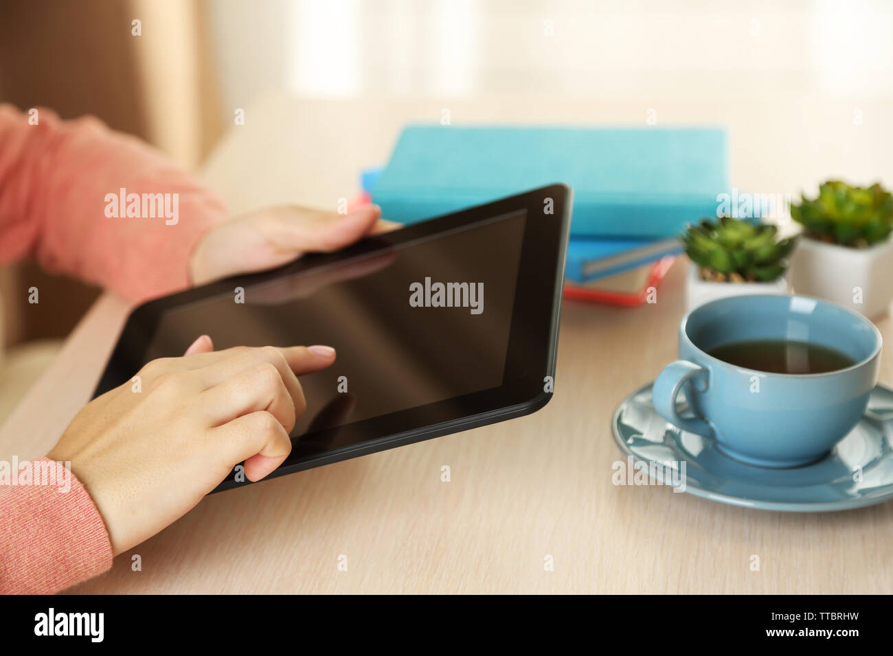Female hand holding PC tablet on home interior background Stock Photo ...