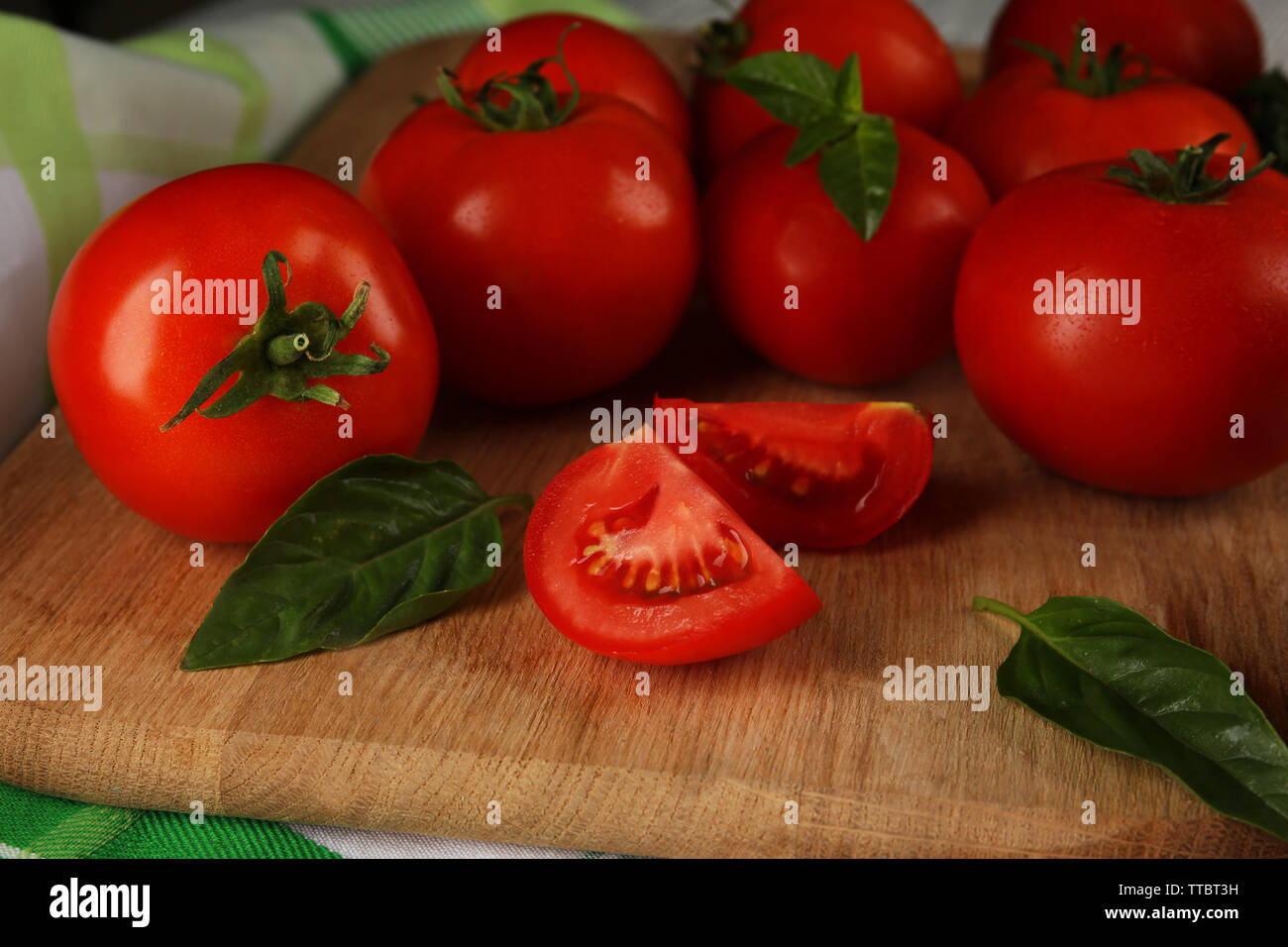 Whole and sliced red tomatoes on cutting board closeup Stock Photo - Alamy