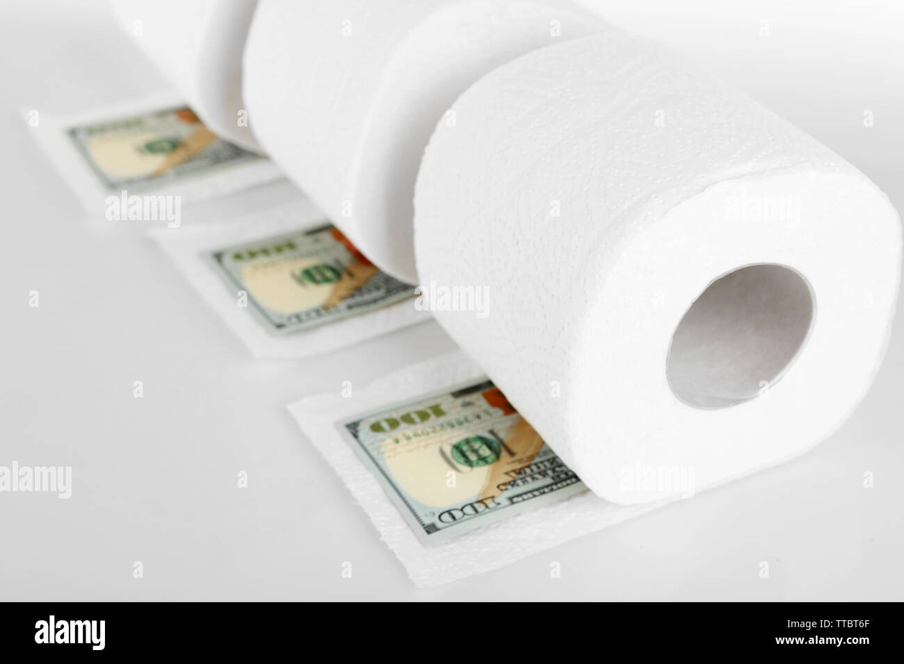White rolls of toilet paper and dollar banknotes isolated on white ...