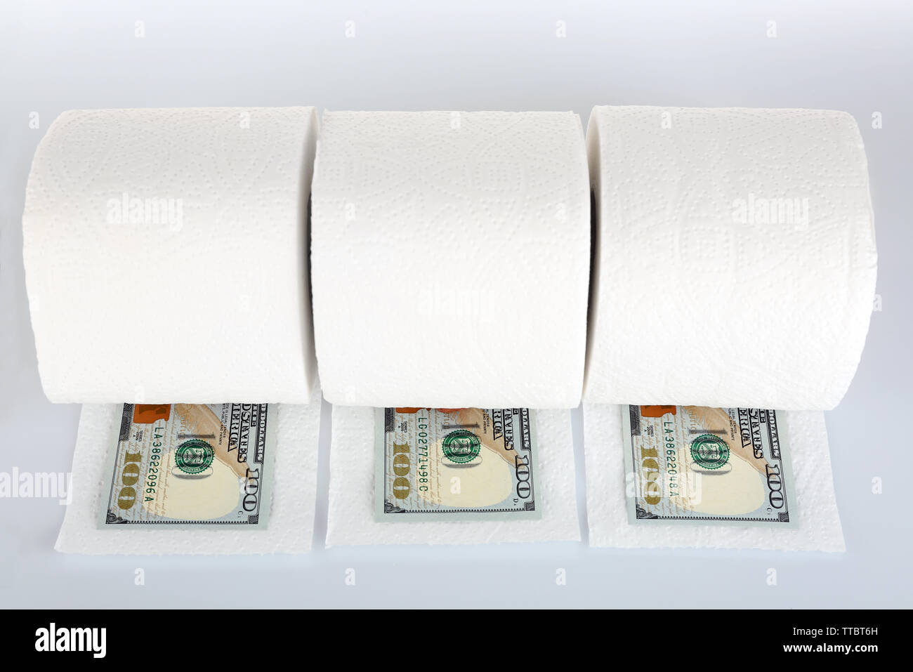 White rolls of toilet paper and dollar banknotes isolated on white ...