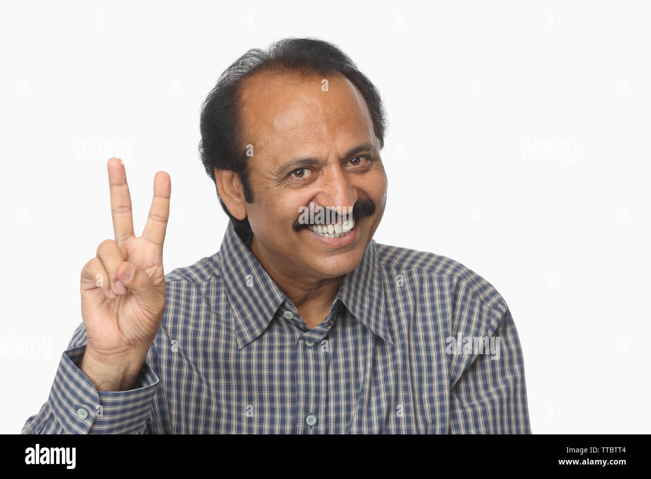 Portrait of a man showing victory sign and smiling Stock Photo - Alamy