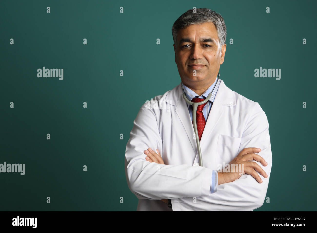 Portrait of a male doctor with arms crossed Stock Photo - Alamy