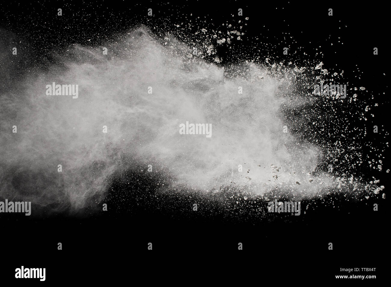 Bizarre forms of white powder explosion cloud against black background ...