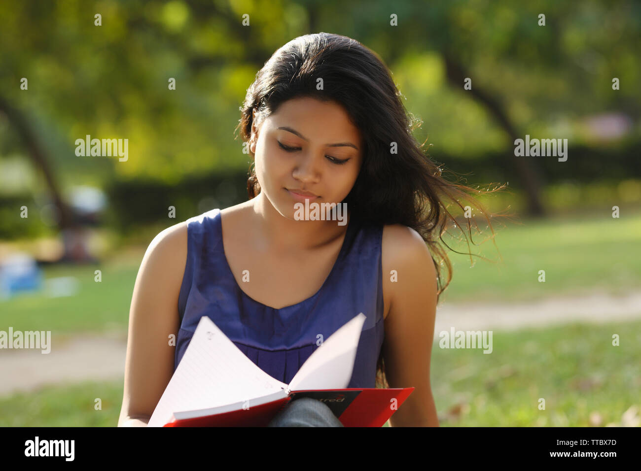 Woman reading a book in a lawn Stock Photo - Alamy