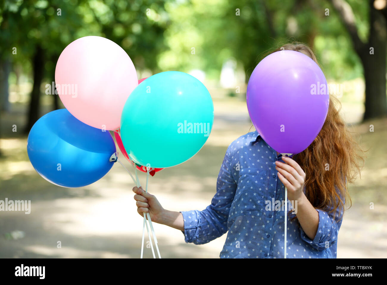 Girl with balloons hiding behind the balloon Stock Photo - Alamy