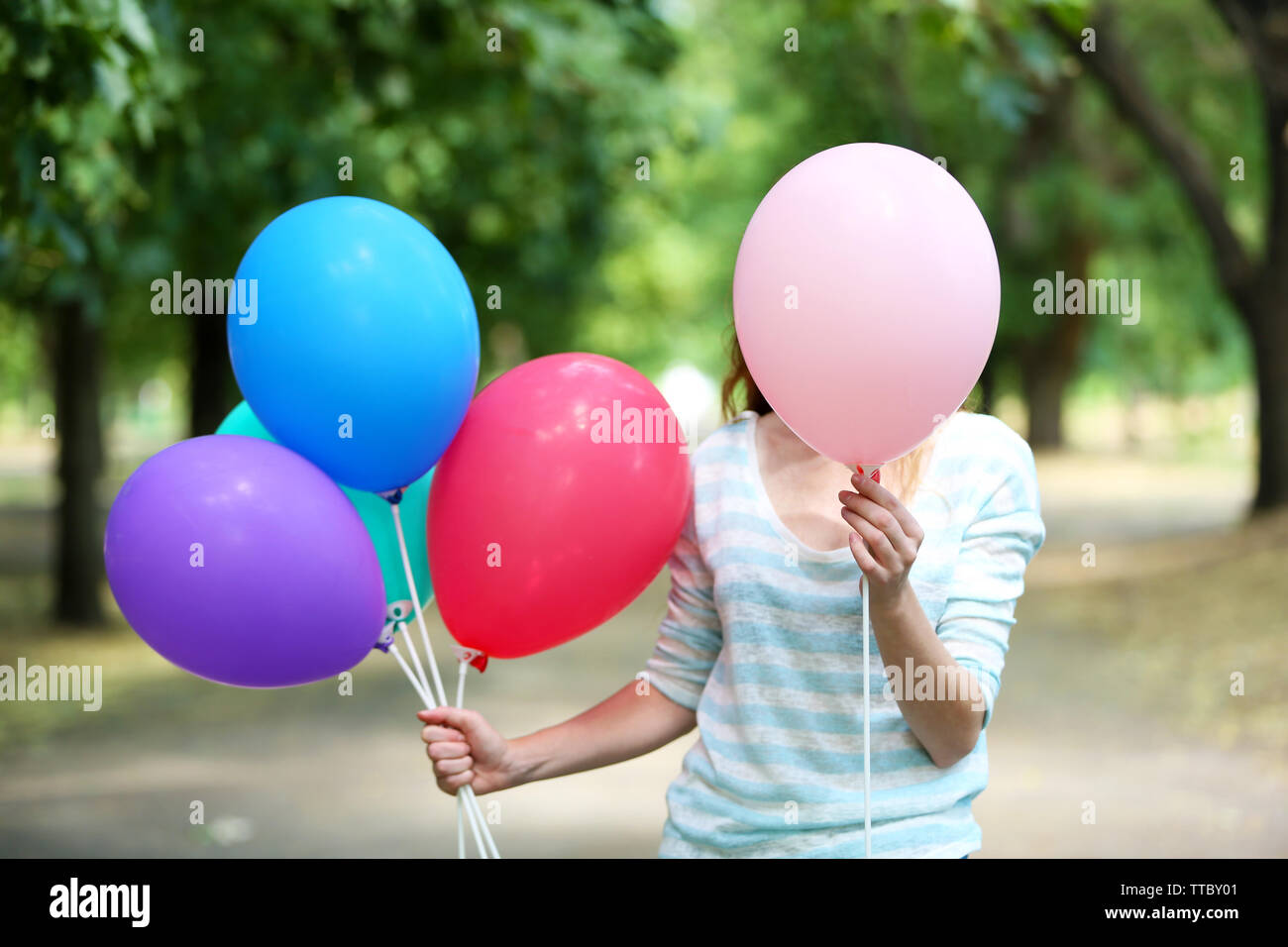 Girl with balloons hiding behind the balloon Stock Photo - Alamy