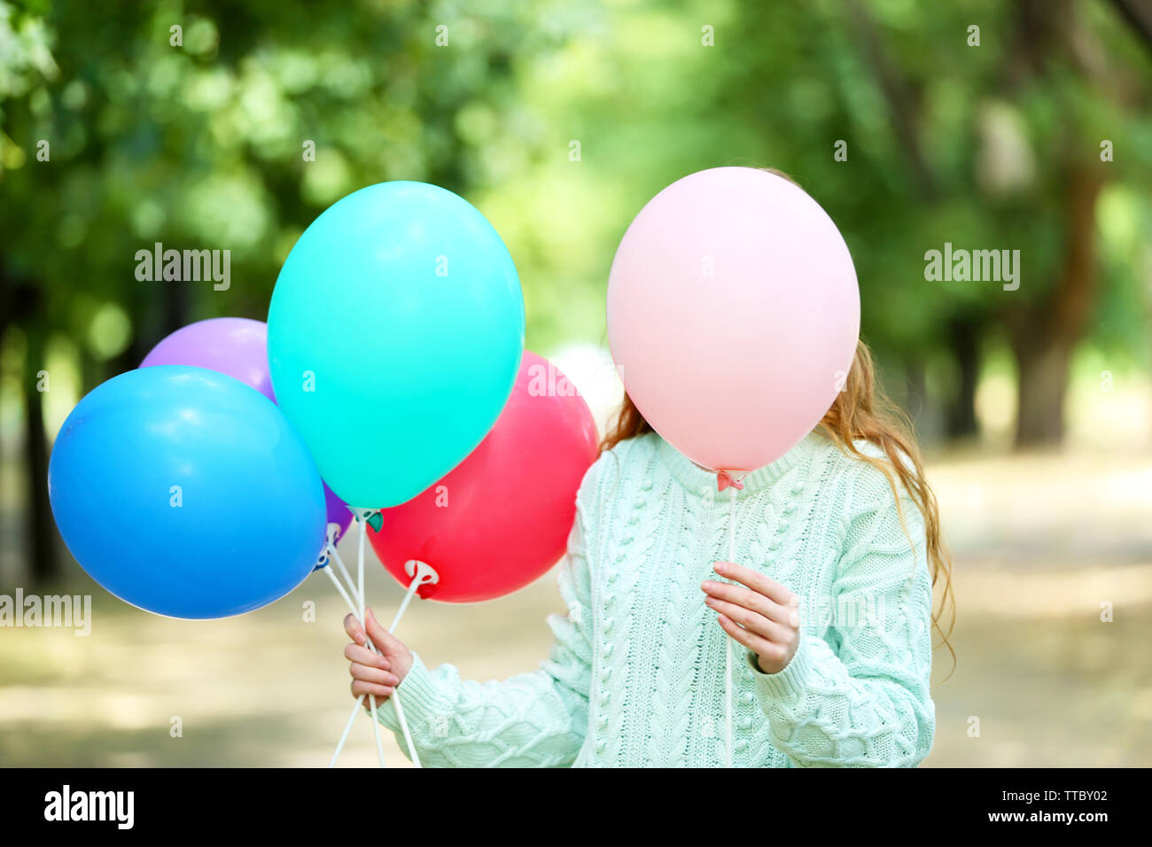 Girl with balloons hiding behind the balloon Stock Photo - Alamy