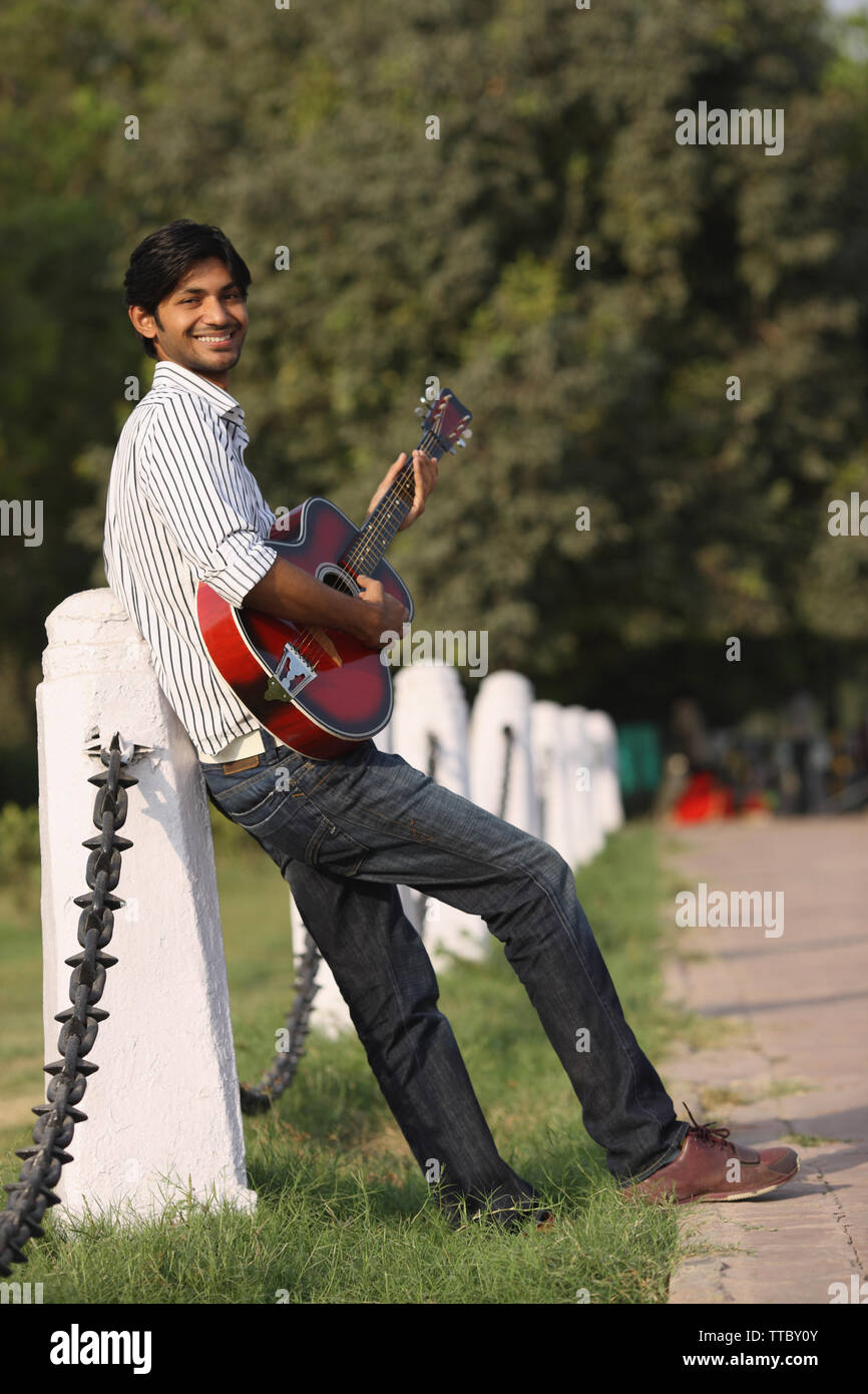 Man playing a guitar and smiling Stock Photo - Alamy