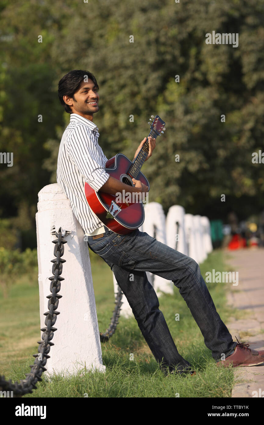 Man playing a guitar and smiling Stock Photo - Alamy