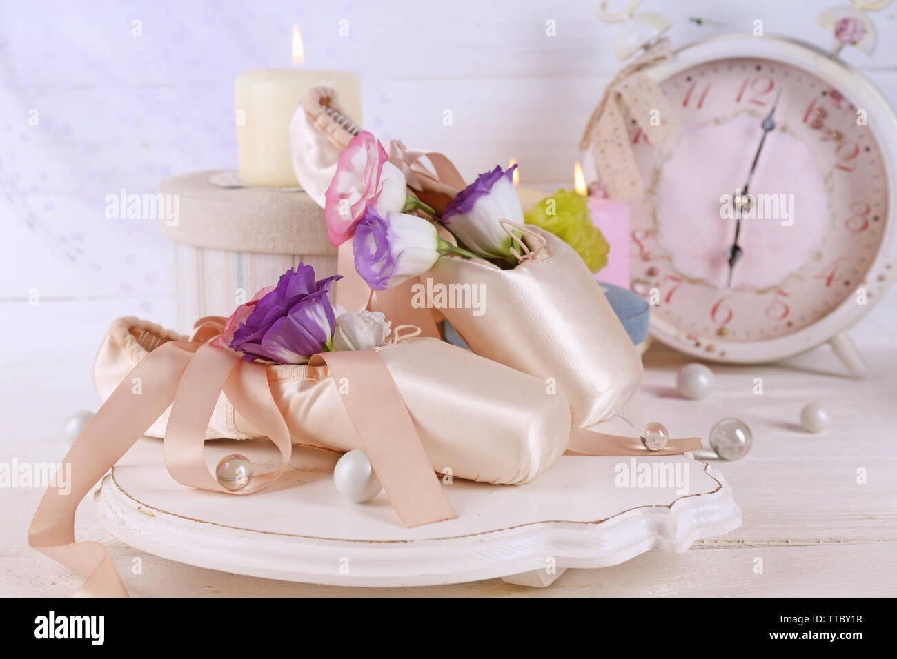 Beautiful composition of ballet shoes, candles, flowers and caskets ...