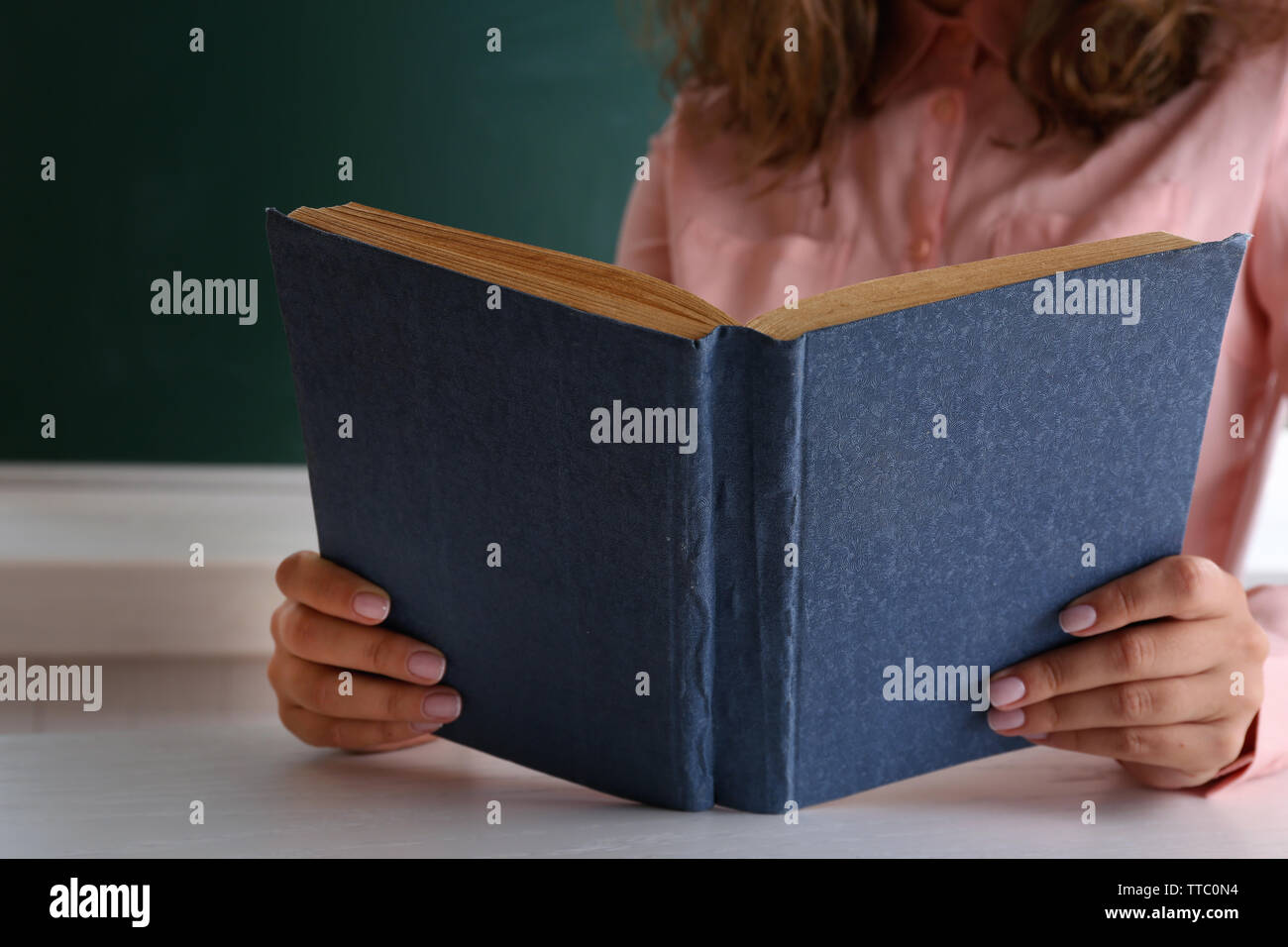 Women hands with book on blackboard background Stock Photo - Alamy
