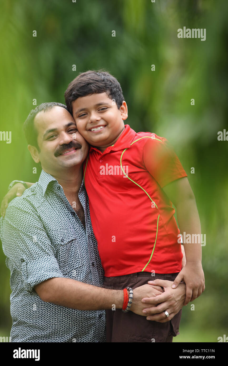 Portrait of a man with his son smiling Stock Photo - Alamy