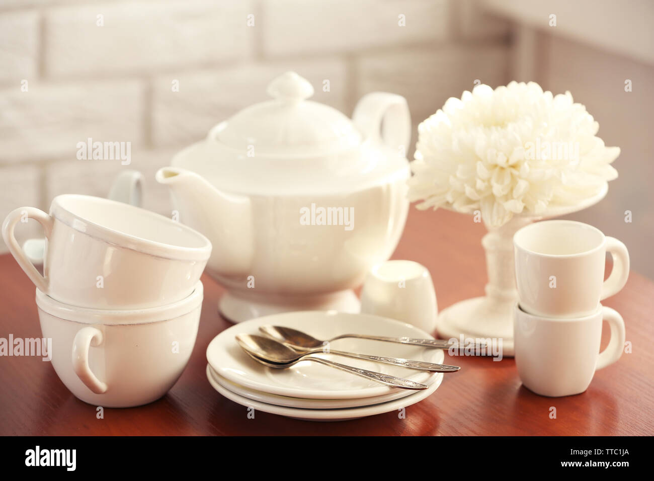 Clean dishes on table on brick wall background Stock Photo - Alamy