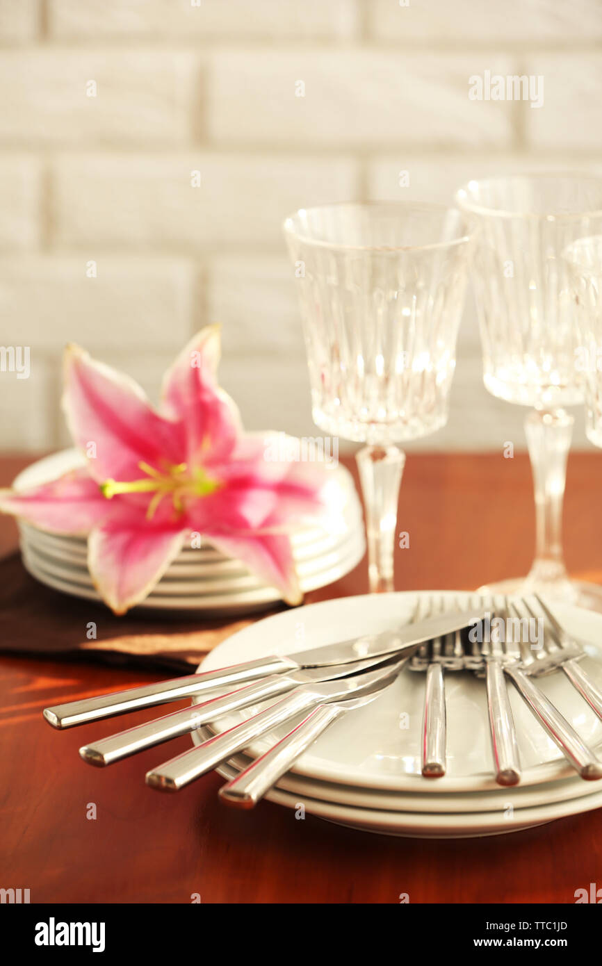 Clean dishes on table on brick wall background Stock Photo - Alamy