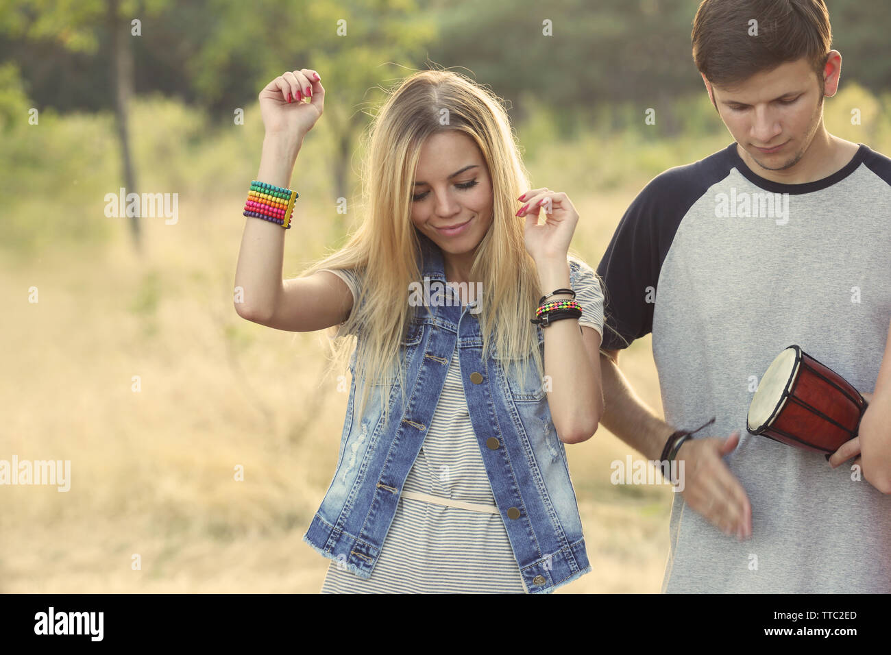 Happy smiling friends playing musical instruments in the forest ...