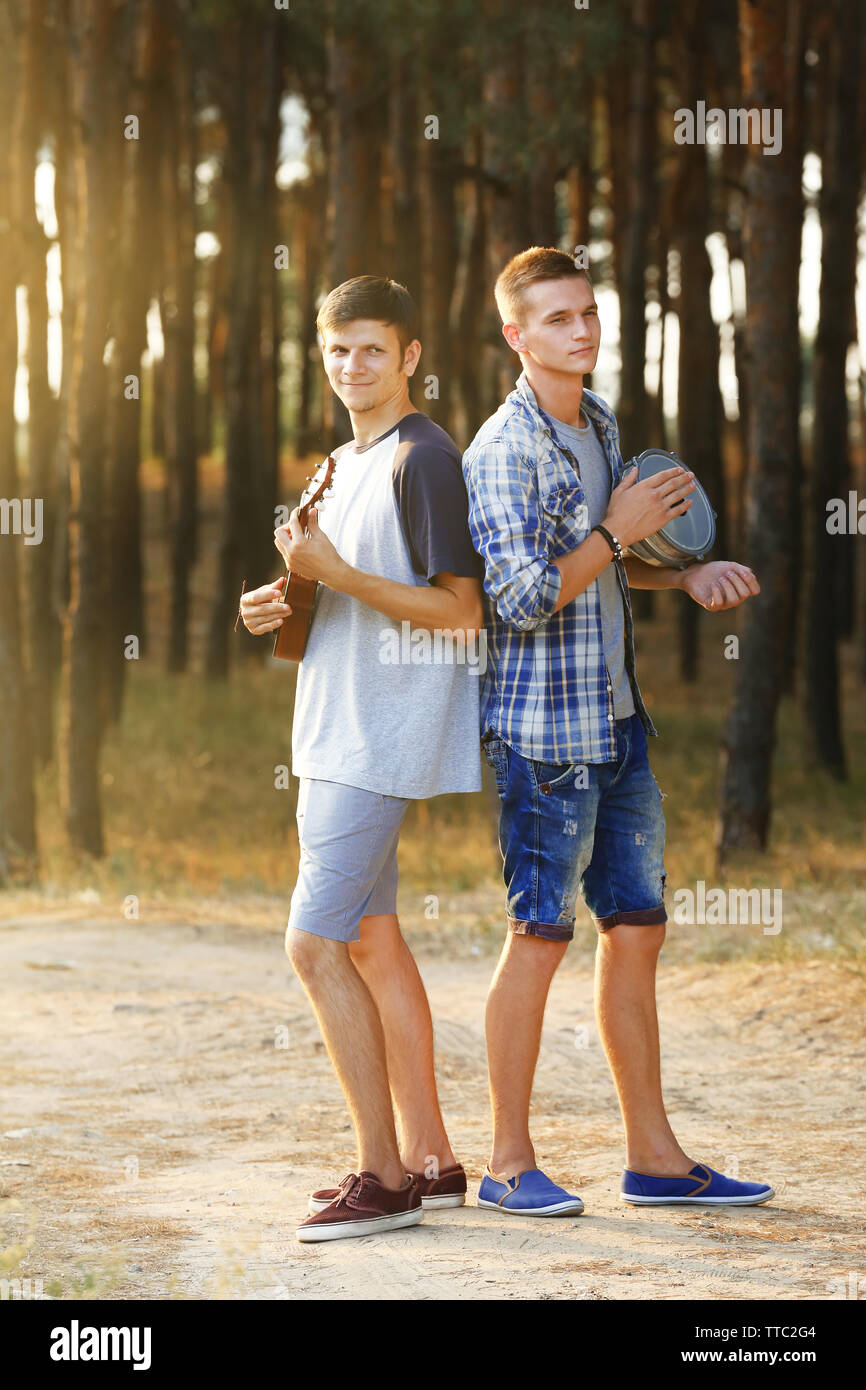 Two handsome guys with musical instruments in the forest outdoors Stock ...