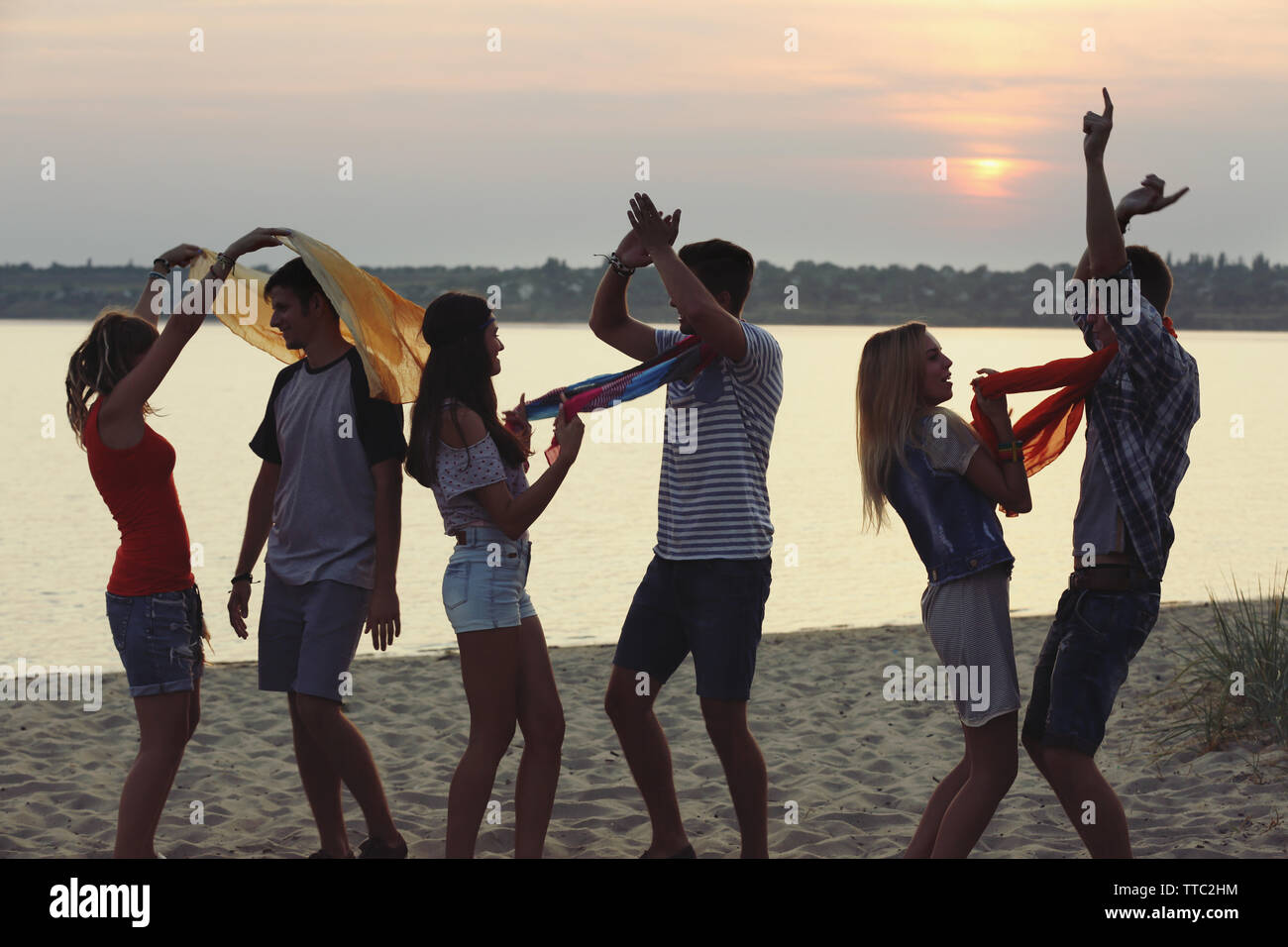Happy friends having fun on river and sky background at sunset Stock ...