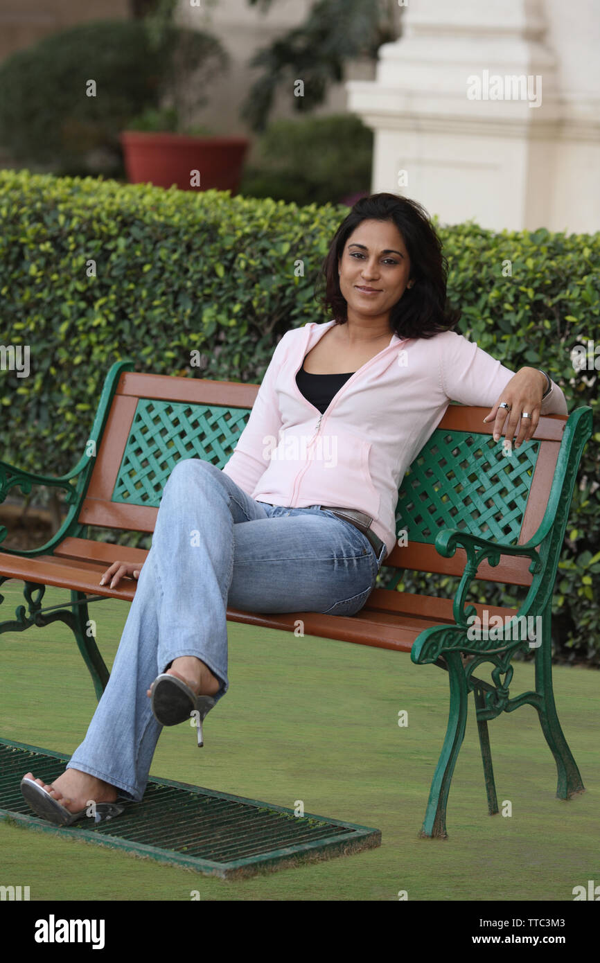 Portrait of a woman sitting on a park bench Stock Photo - Alamy