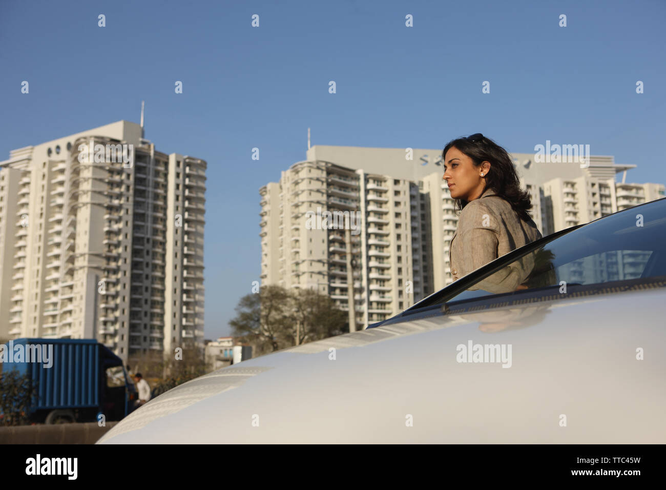 Woman leaning against a car Stock Photo - Alamy